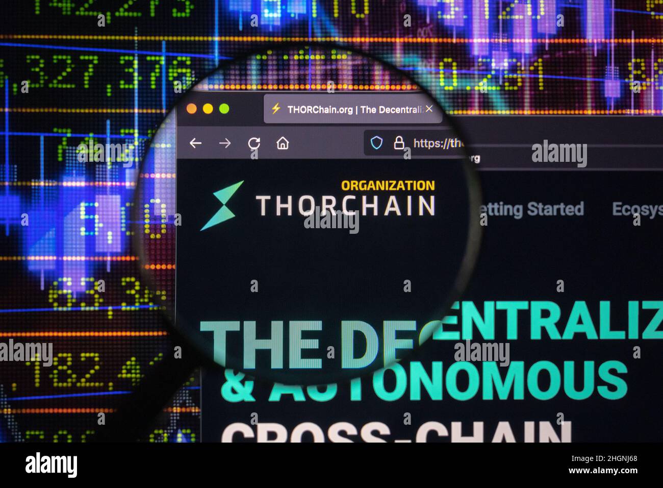 Thorchain crypto company logo on a website, seen on a computer screen through a magnifying glass ...