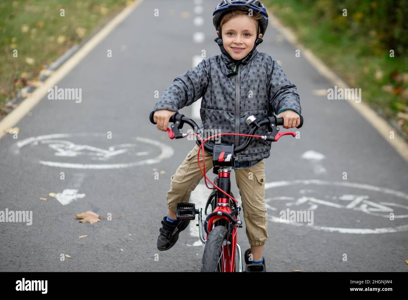 Boy in a helmet on a bicycle rides on a bike path in the park Stock ...
