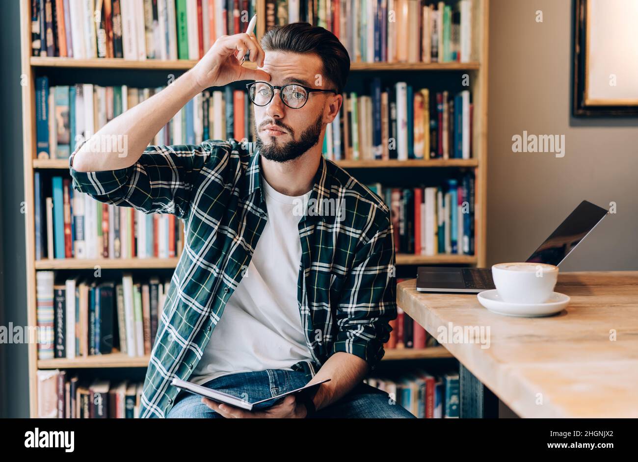 thoughtful young man learning and studying in library Stock Photo - Alamy