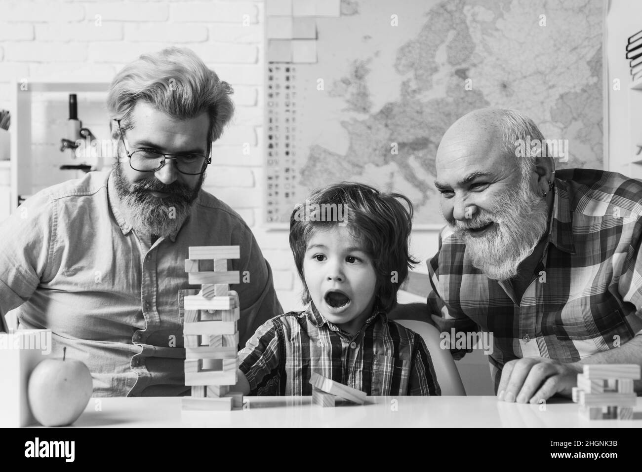 Three generations of men having fun together. Grandfather teaching ...