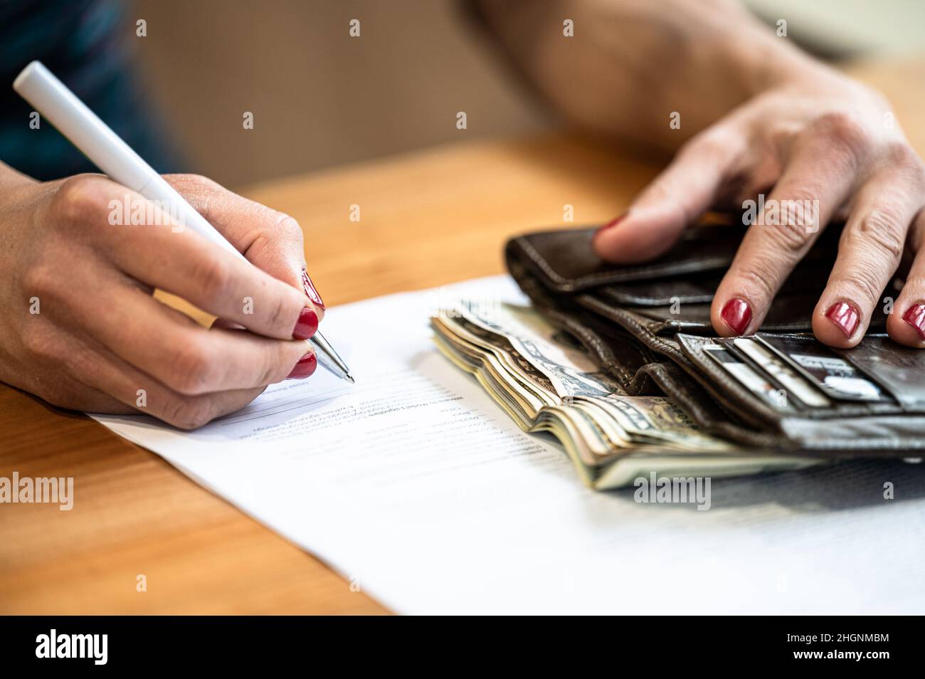 Hand signing check hi-res stock photography and images - Alamy