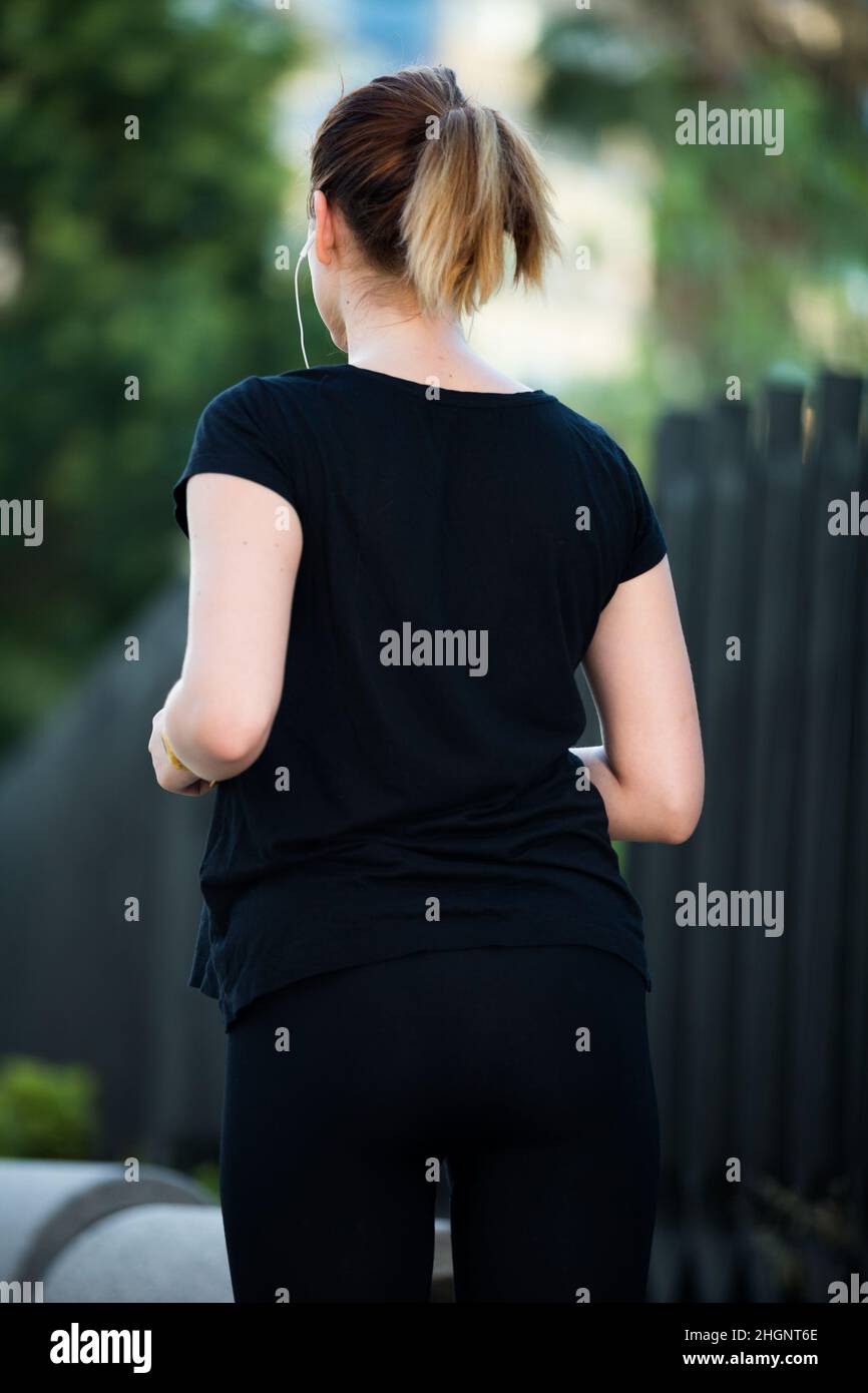 Back view of girl running with music Stock Photo - Alamy