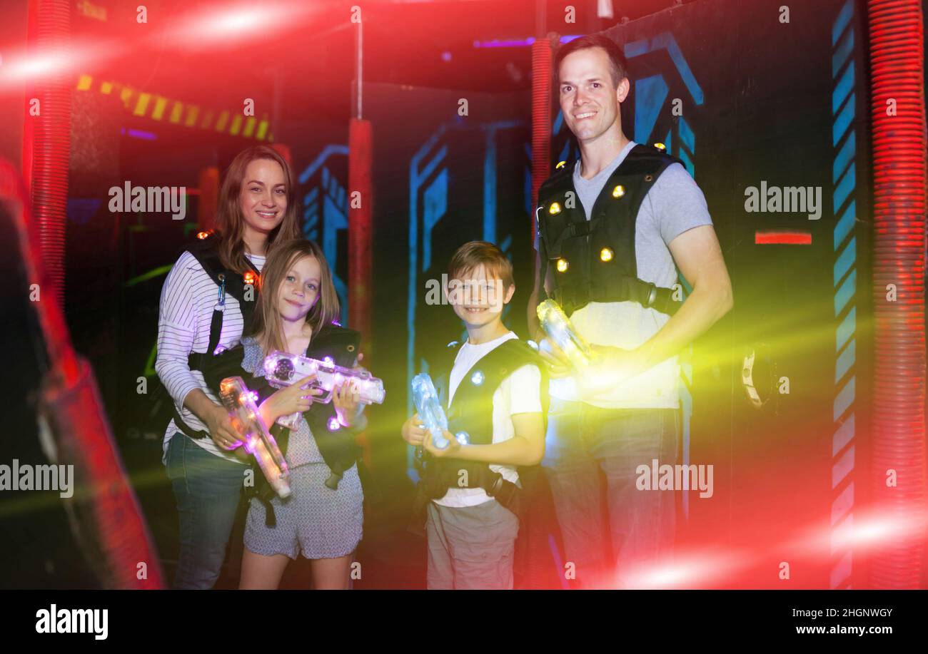 Parents and children playing laser tag in beams Stock Photo - Alamy