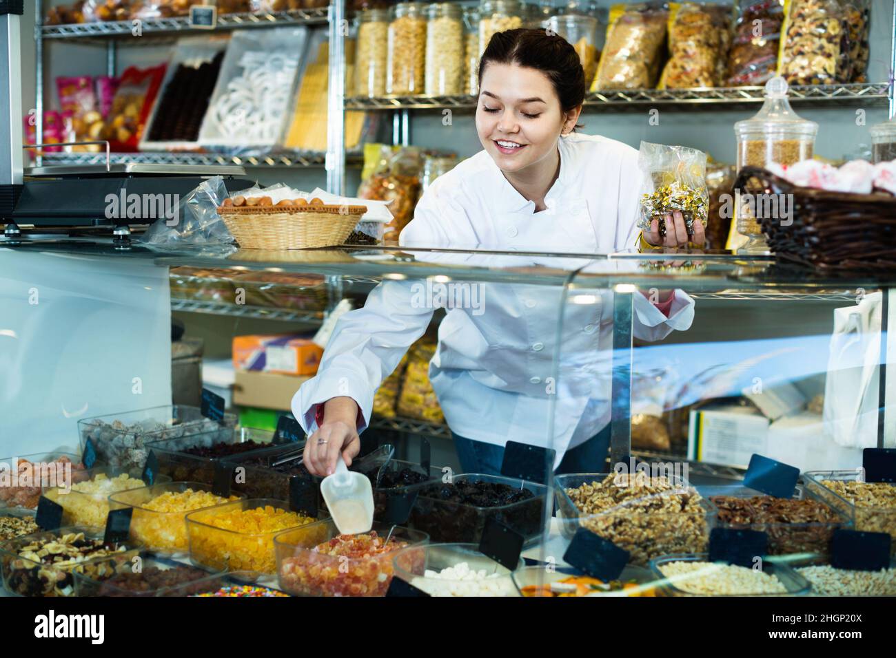 Girl in uniform selling candied fruits and nuts Stock Photo - Alamy