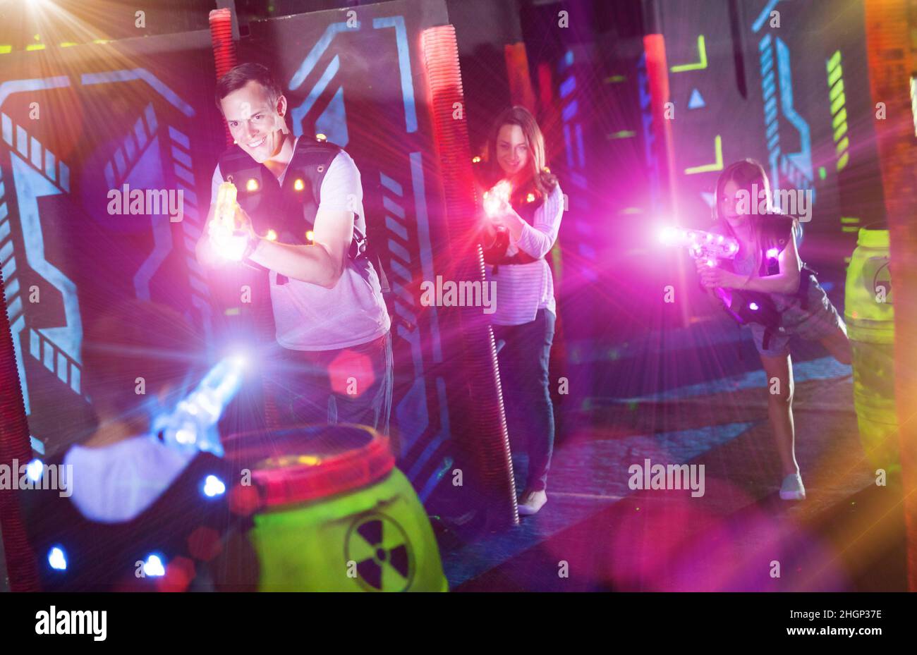 Parents and children playing laser tag in beams Stock Photo - Alamy