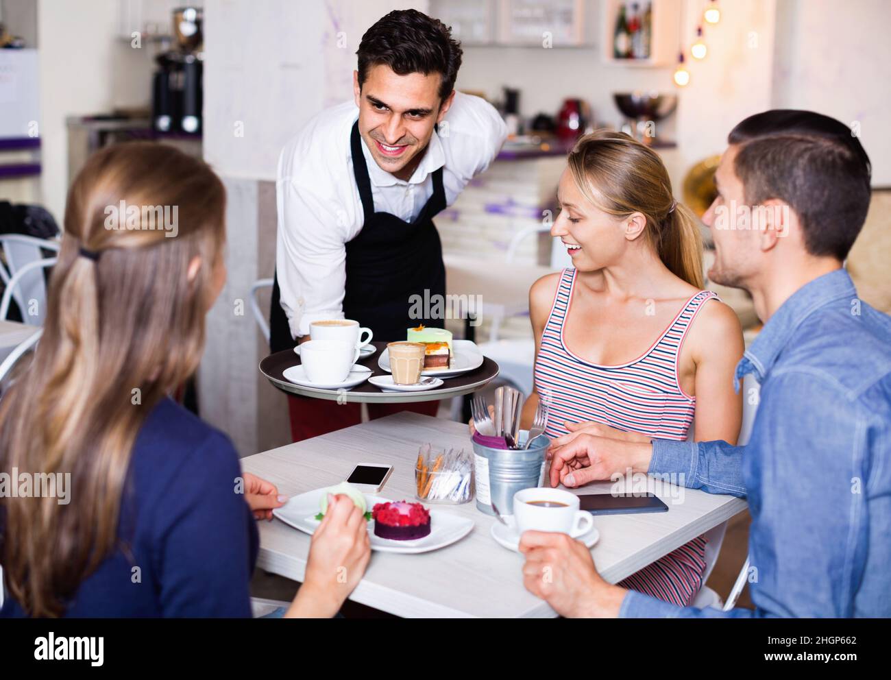Waiter showing hospitality and serving visitors Stock Photo - Alamy