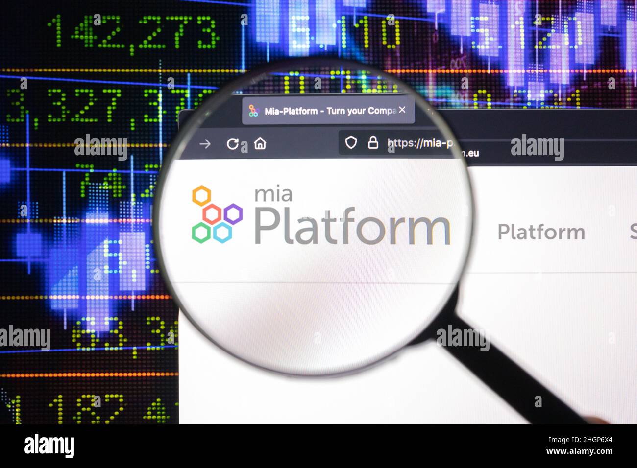 Mia Platform company logo on a website with blurry stock market ...