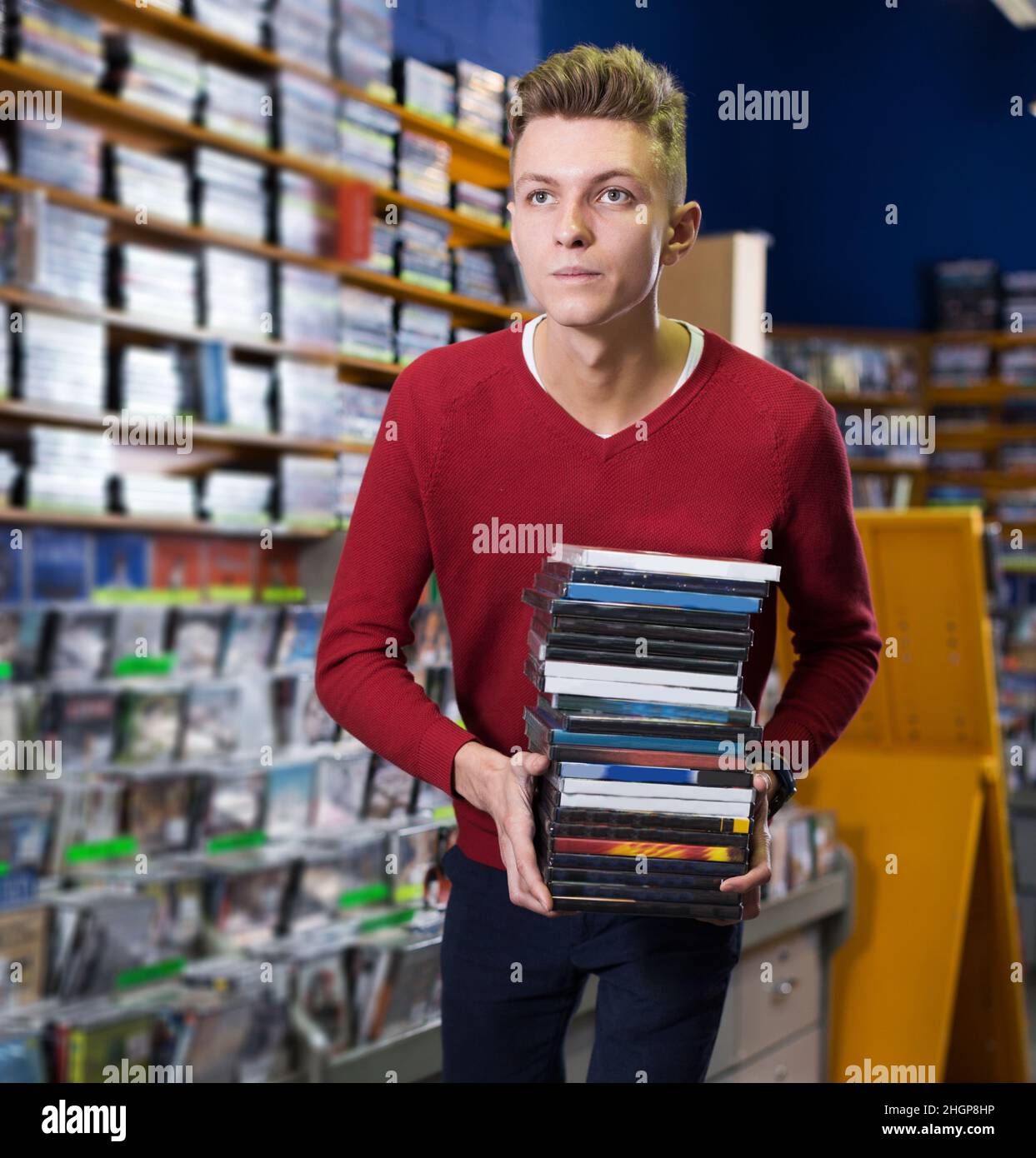 guy holding pile of boxes with DVDs Stock Photo - Alamy