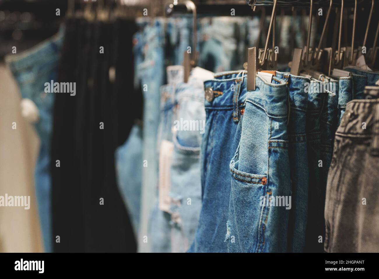 Rack with jeans in clothing store Stock Photo - Alamy