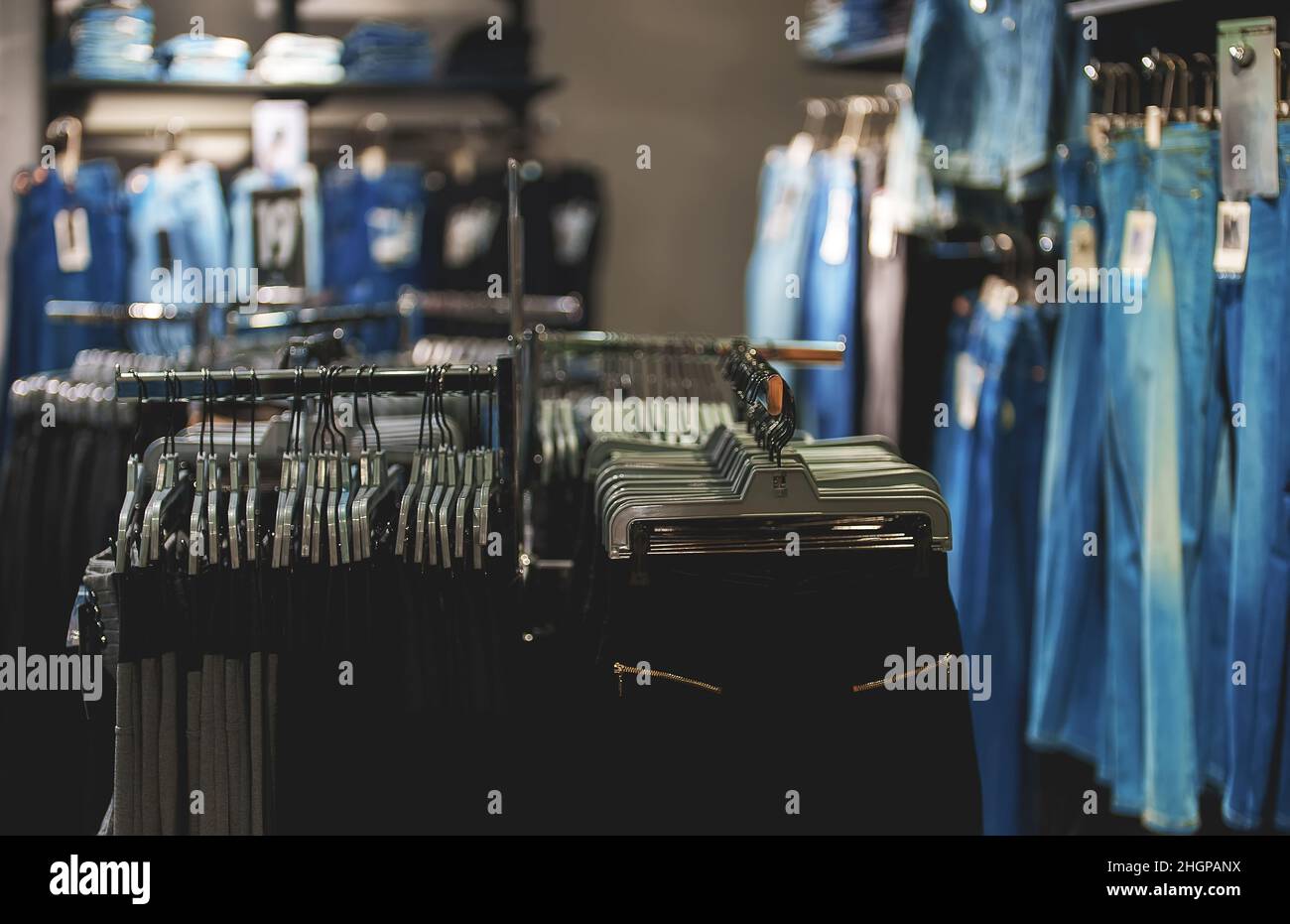 Racks with jeans and pants in clothing store Stock Photo - Alamy