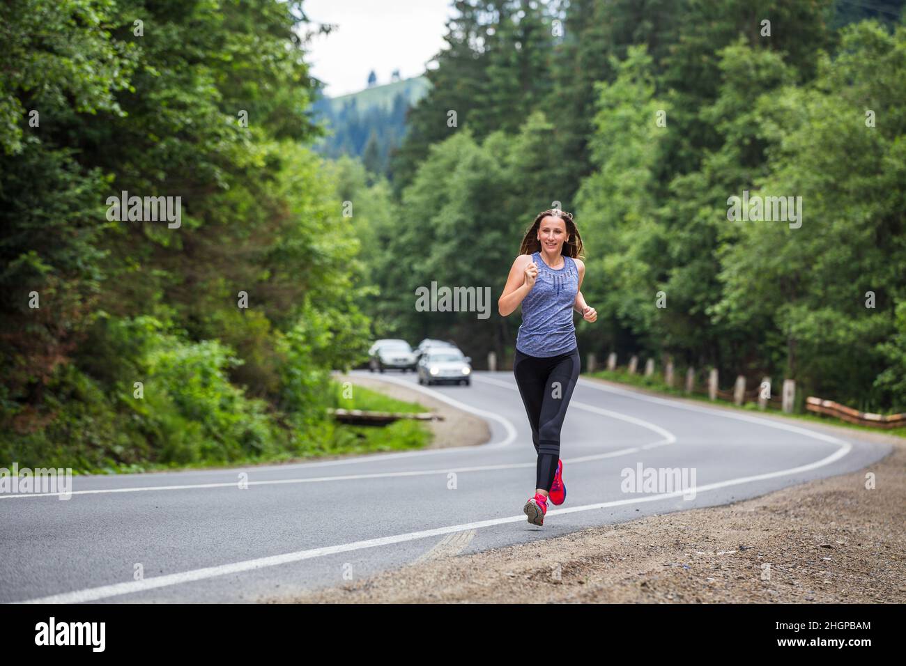 Runner woman running on the mountain road through the forest Stock ...