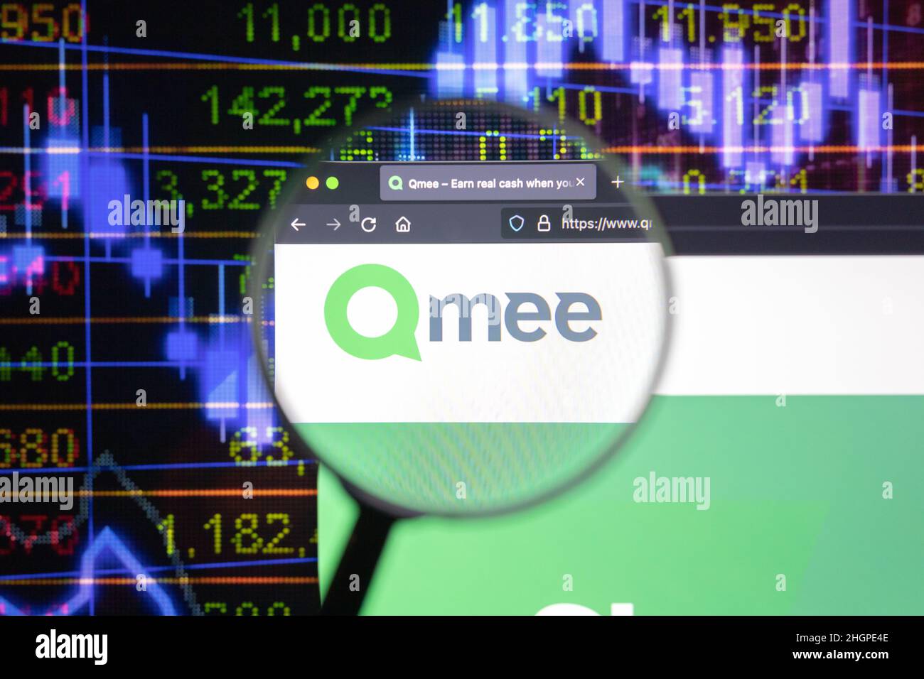 Qmee company logo on a website with blurry stock market developments in ...