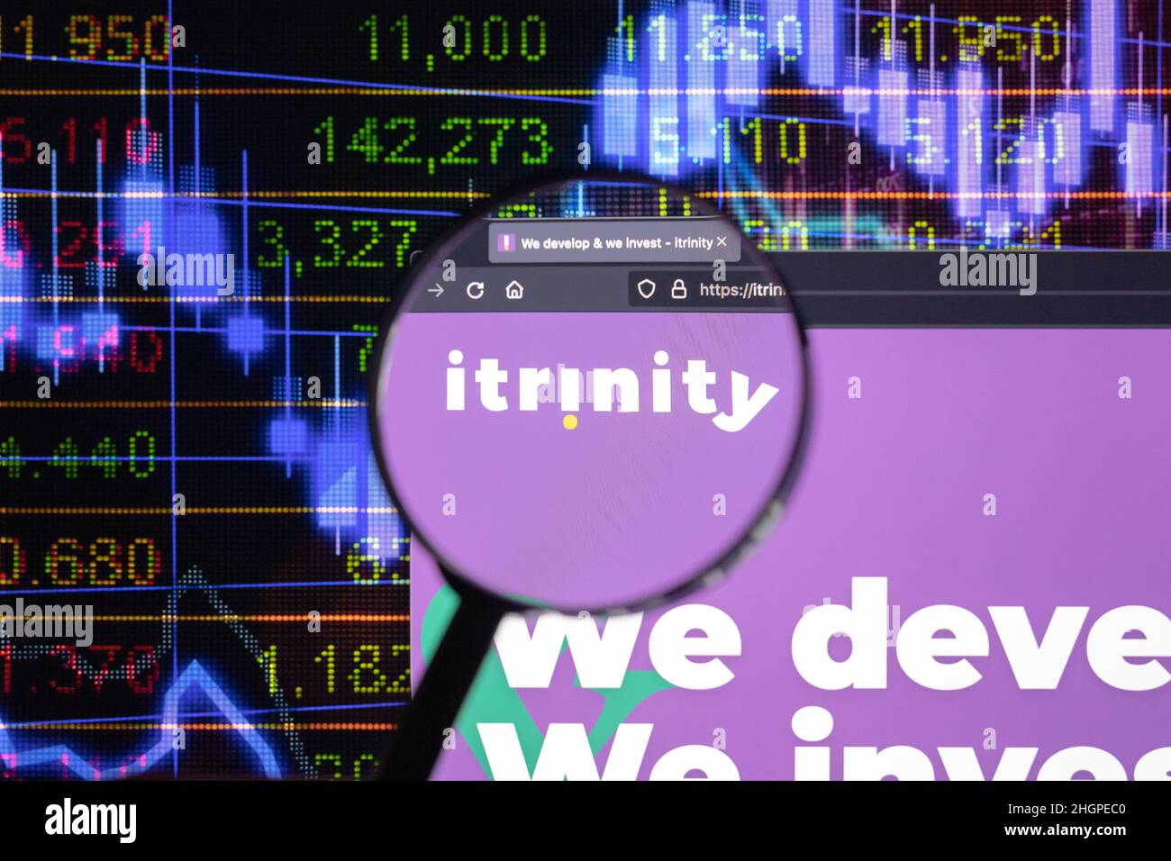 Itrinity company logo on a website with blurry stock market developments in the background, seen ...
