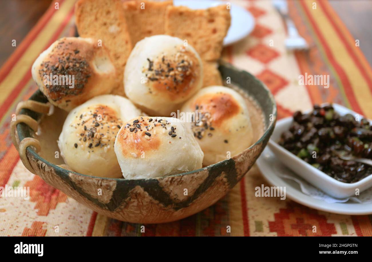 Homemade Argentinian Sesame Table Rolls in a Wooden Basket with Black ...