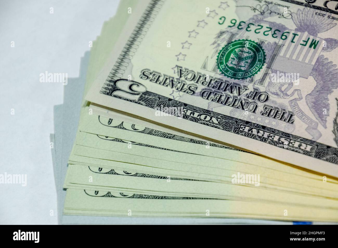 The cistern of banknotes lies on a white table. Lots of dollars, a wad ...