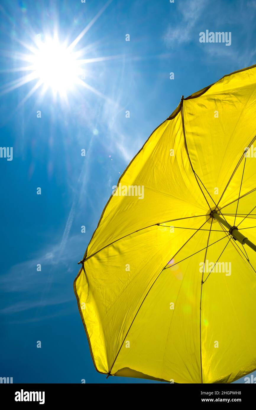 Yellow Umbrella with Bright Sun and Blue Sky Stock Photo - Alamy