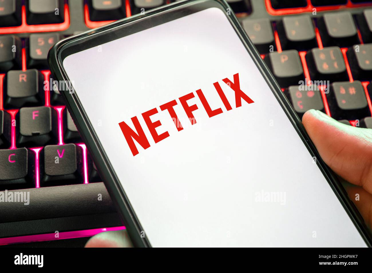 Red netflix logo on mobile phone display with color keyboard in the ...
