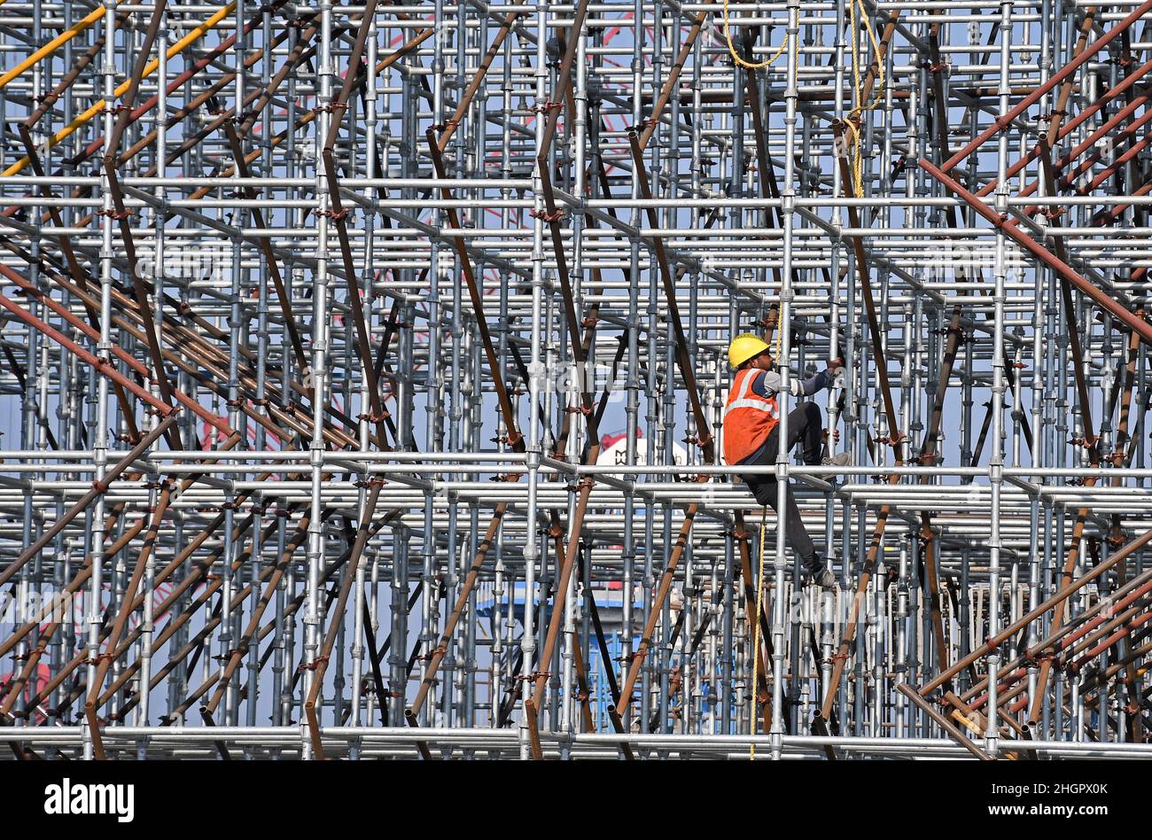 A labourer climbs on a scaffolding at the coastal road construction ...