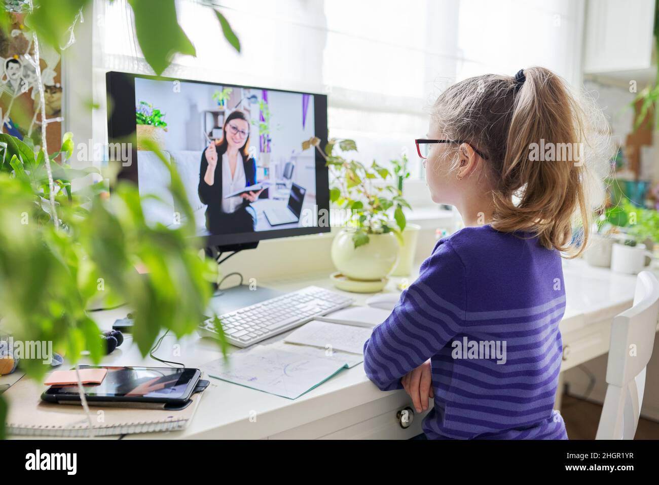 Girl child studying at home using a computer for video lesson Stock Photo - Alamy