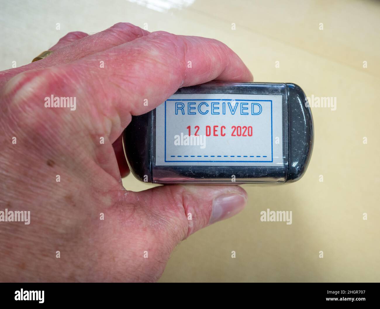 Unidentifiable male date stamping a document using a Date ink stamp ...
