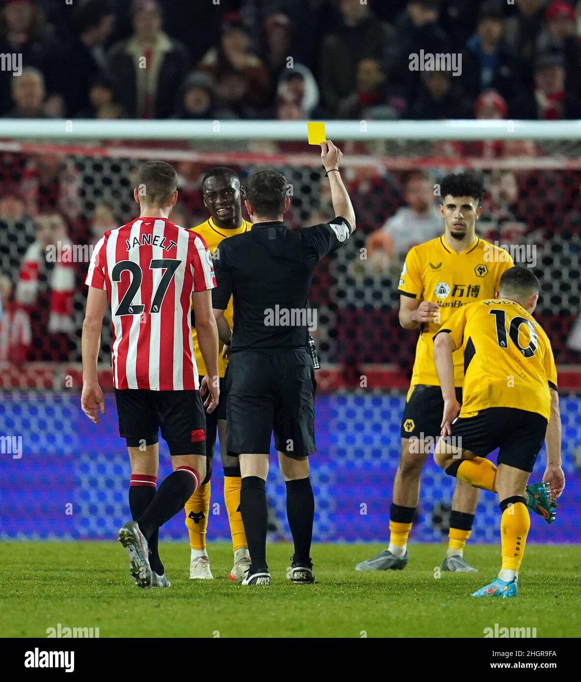 Referee Peter Banks brandishes a yellow card to Wolverhampton Wanderers ...