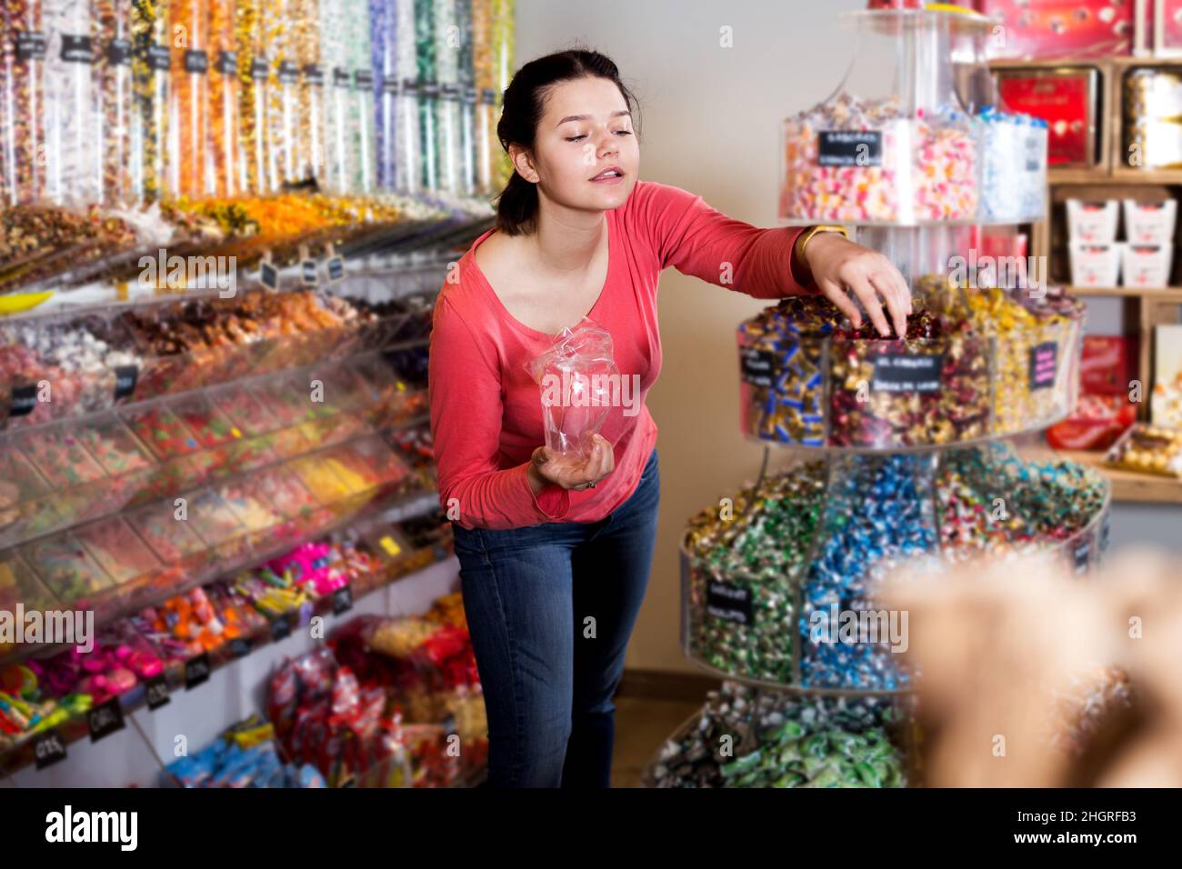 Woman posing to photographer picking different candies Stock Photo - Alamy
