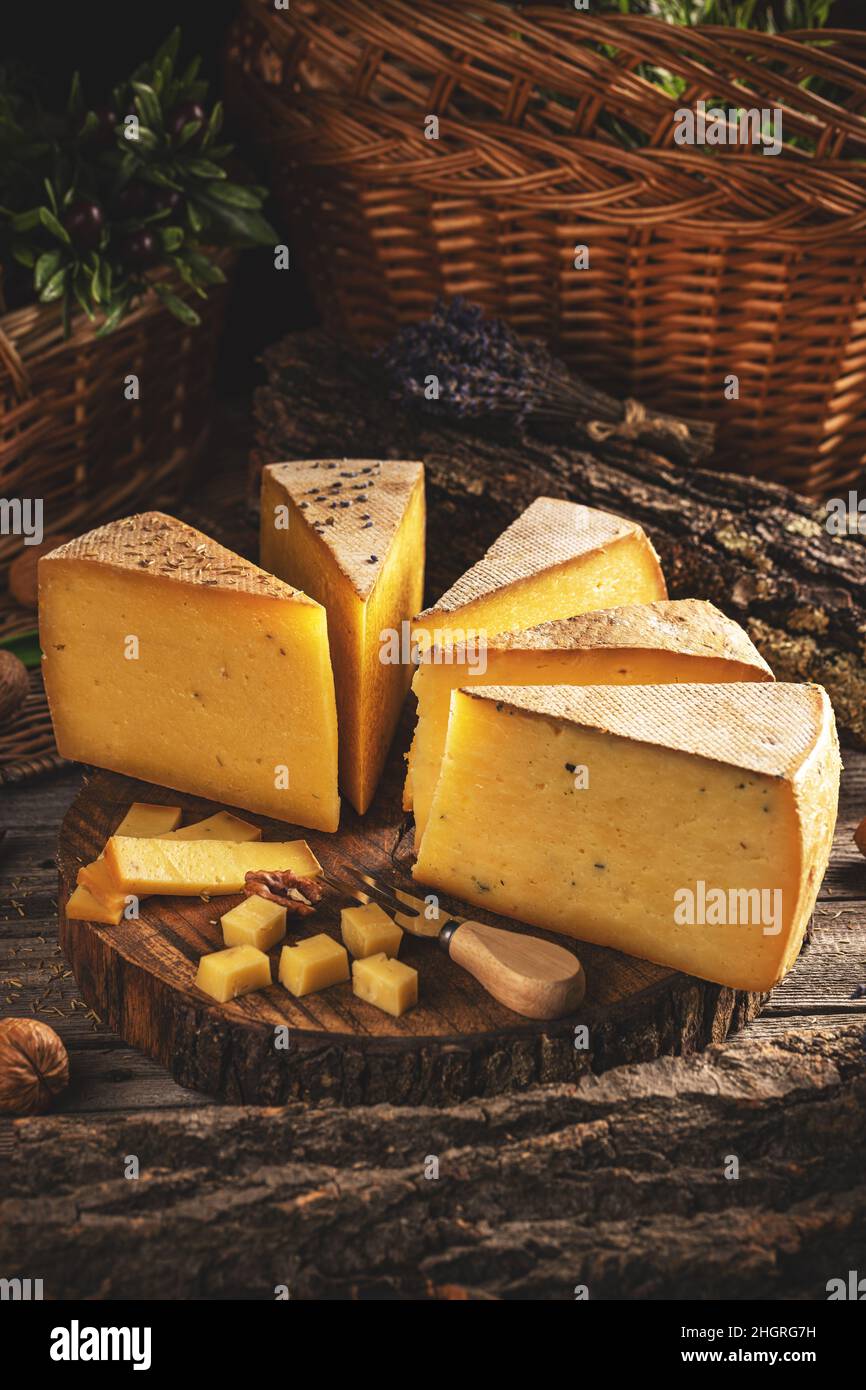 Still life of various flavour of homemade aged cheese on wooden board ...