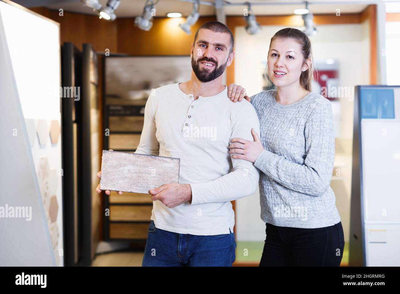 Joyful couple looking sample of ceramic tile Stock Photo - Alamy