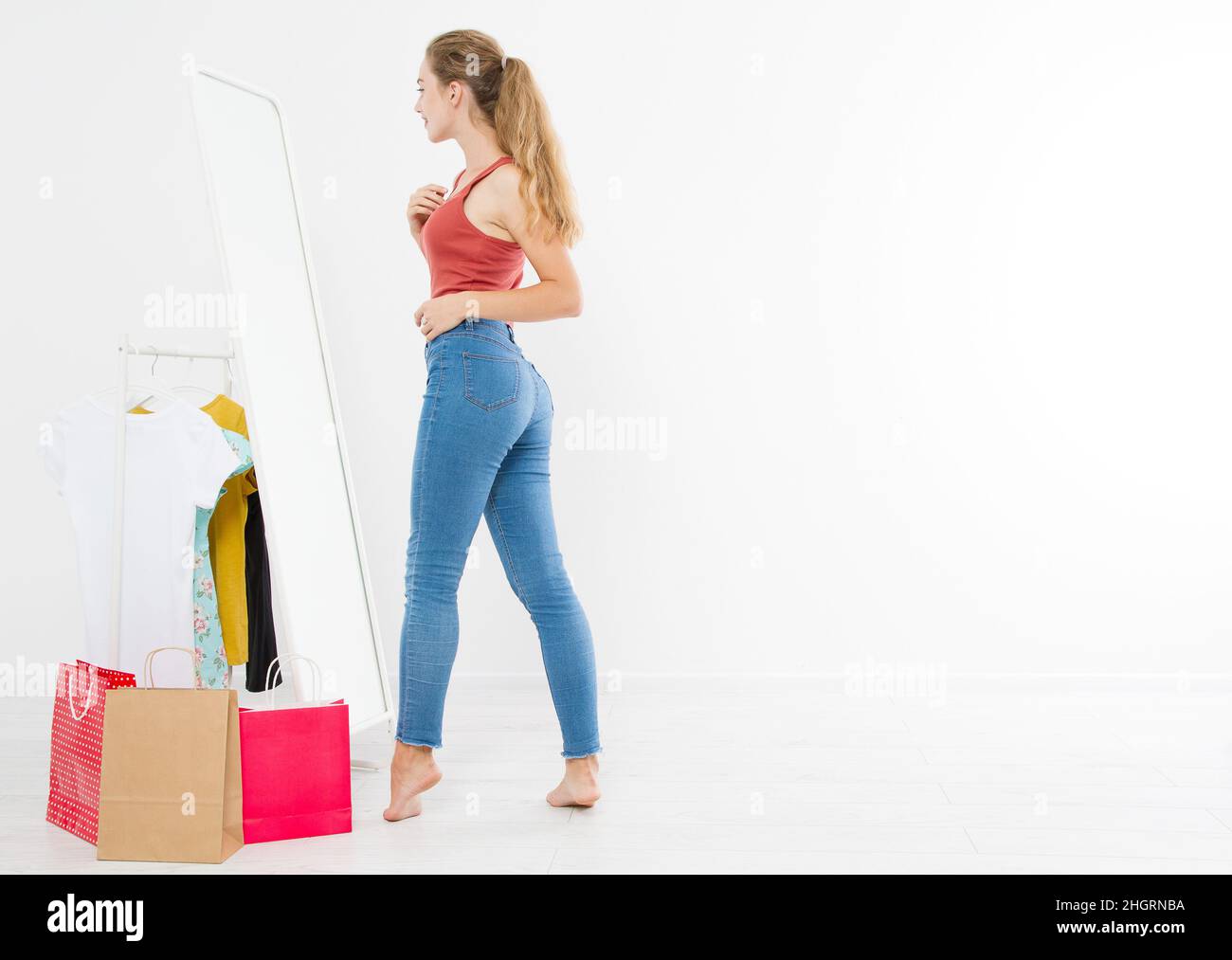 Girl dress up and looking in mirror. Shopping and weight loss concept ...