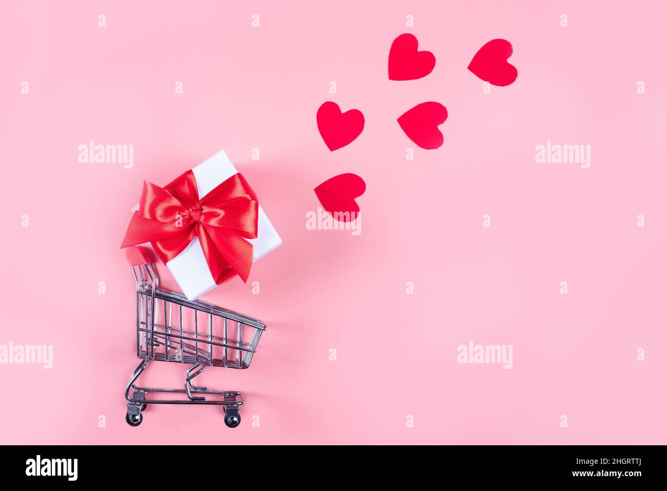 Flat lay. Shopping cart for purchases, gifts on a pink background Stock ...