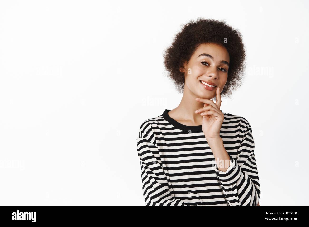 Portrait of cute african girl smiling, looking with interested ...