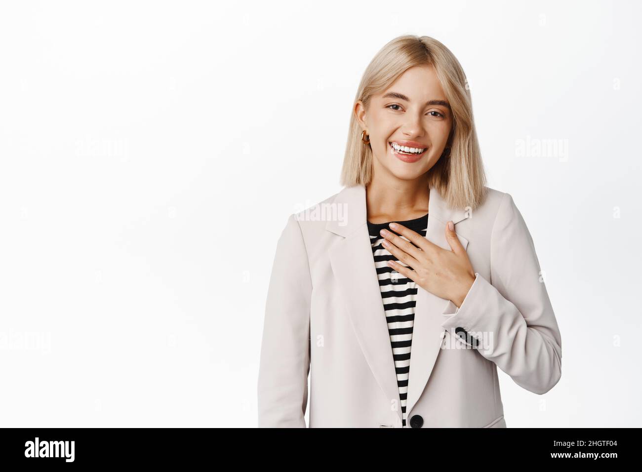 Portrait of smiling blond businesswoman, office lady holding hand on ...