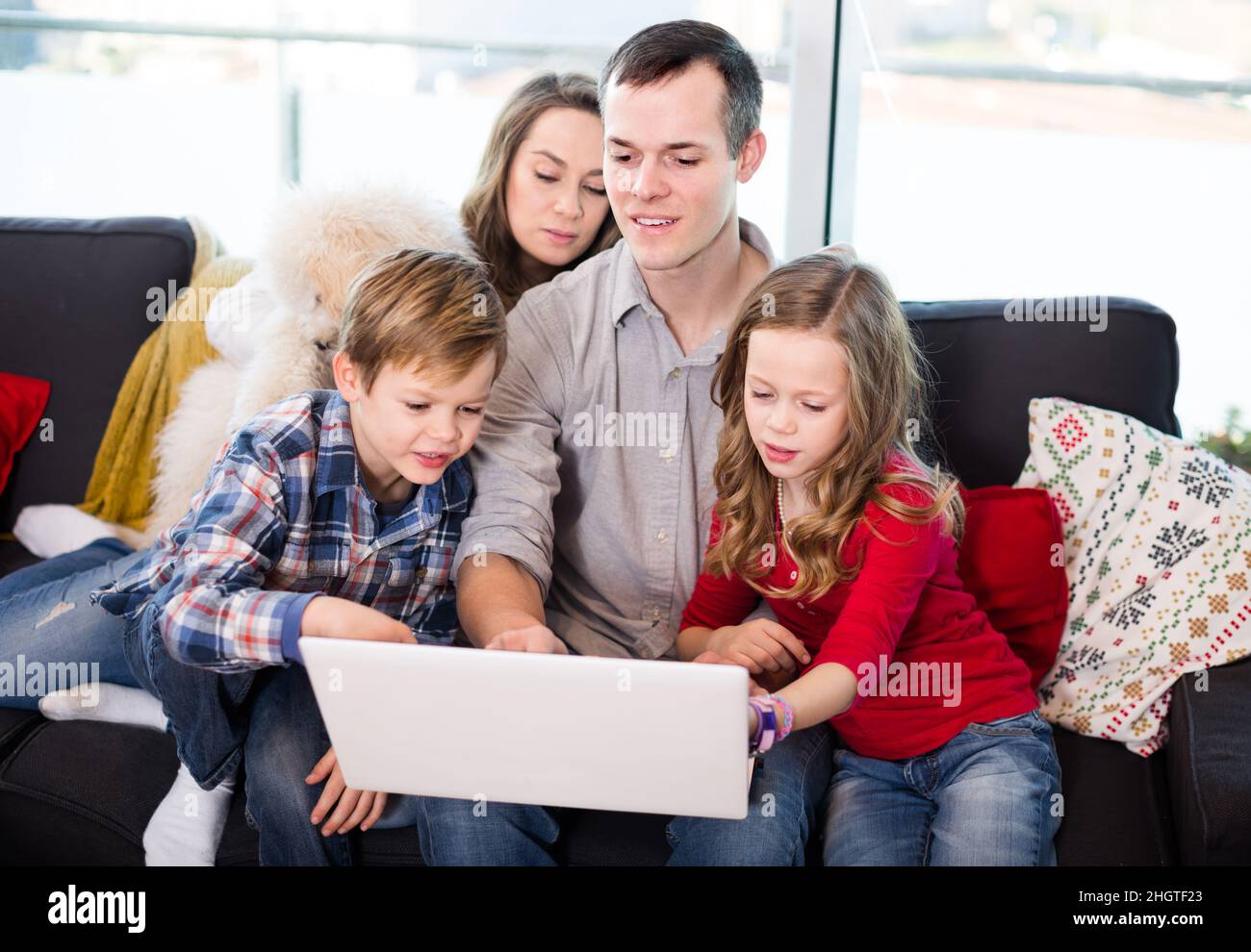Young cheerful family watching movie on laptop together at home Stock ...
