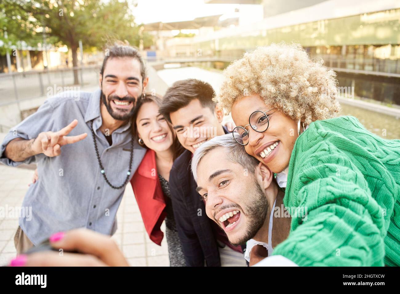 Group of cheerful friends taking smiling selfies outdoors Stock Photo ...