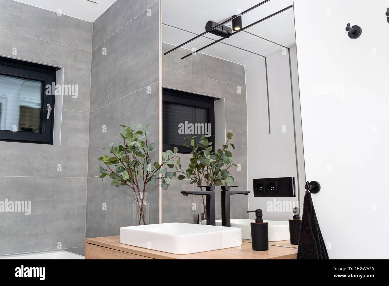 Black sconce mounted in a large mirror in the bathroom, visible LED ...