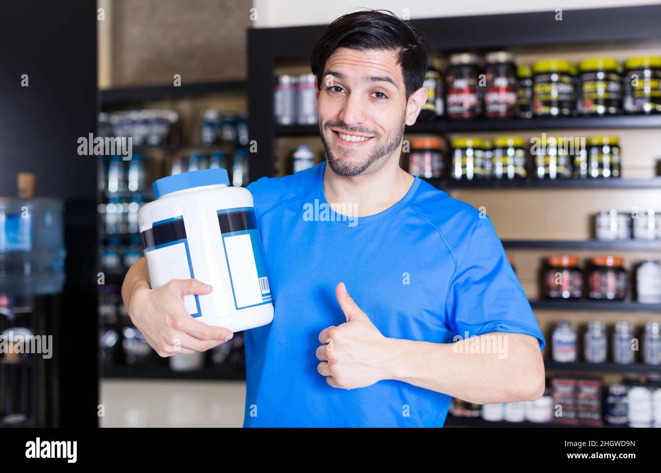 bodybuilder keeping thumb up and sport nutrition Stock Photo - Alamy