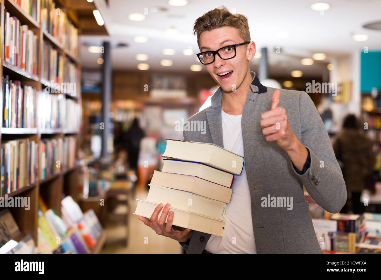Portrait of nice guy standing with pile of books Stock Photo - Alamy