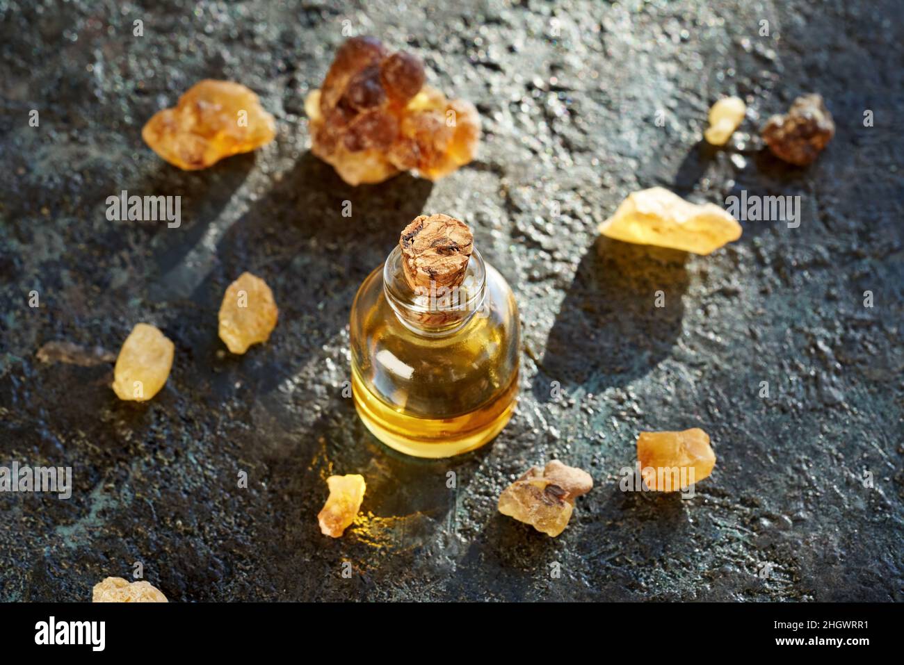 A bottle of frankincense essential oil with boswellia resin on a table ...