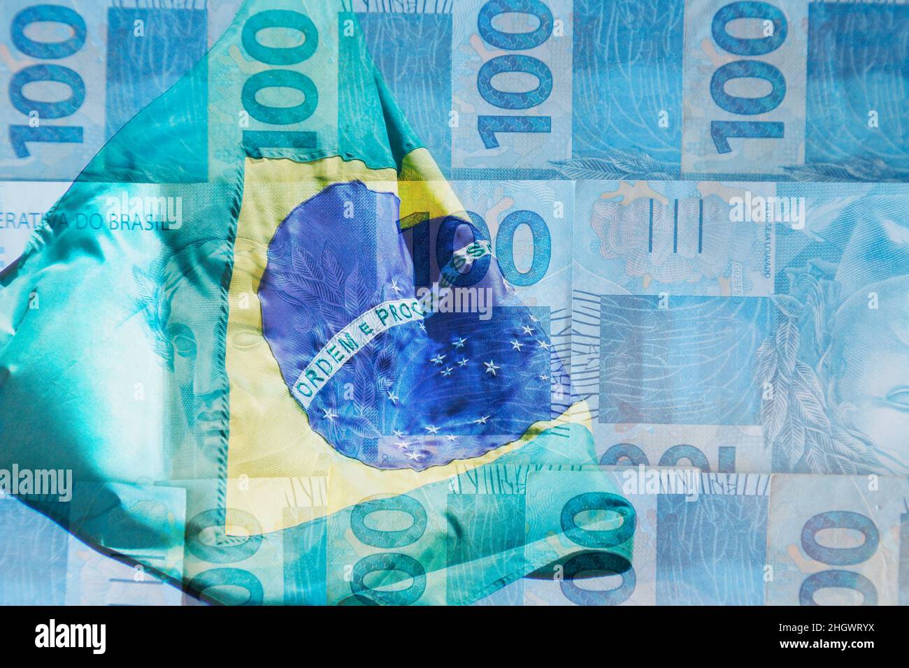 brazil money concept - brazilian flag and one hundred reais bills ...