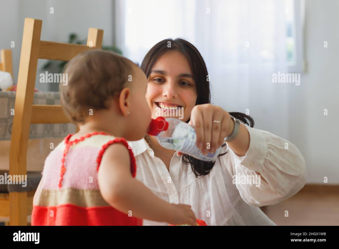 Woman drink water hold baby hi-res stock photography and images - Alamy