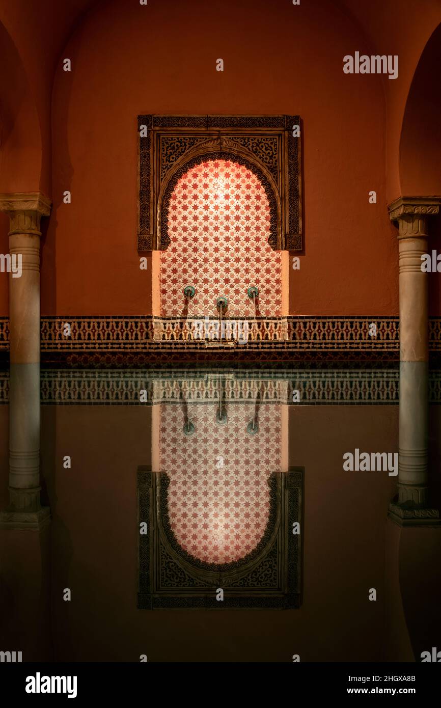 Fountain with three mouths and reflection in the water of a bath with ...