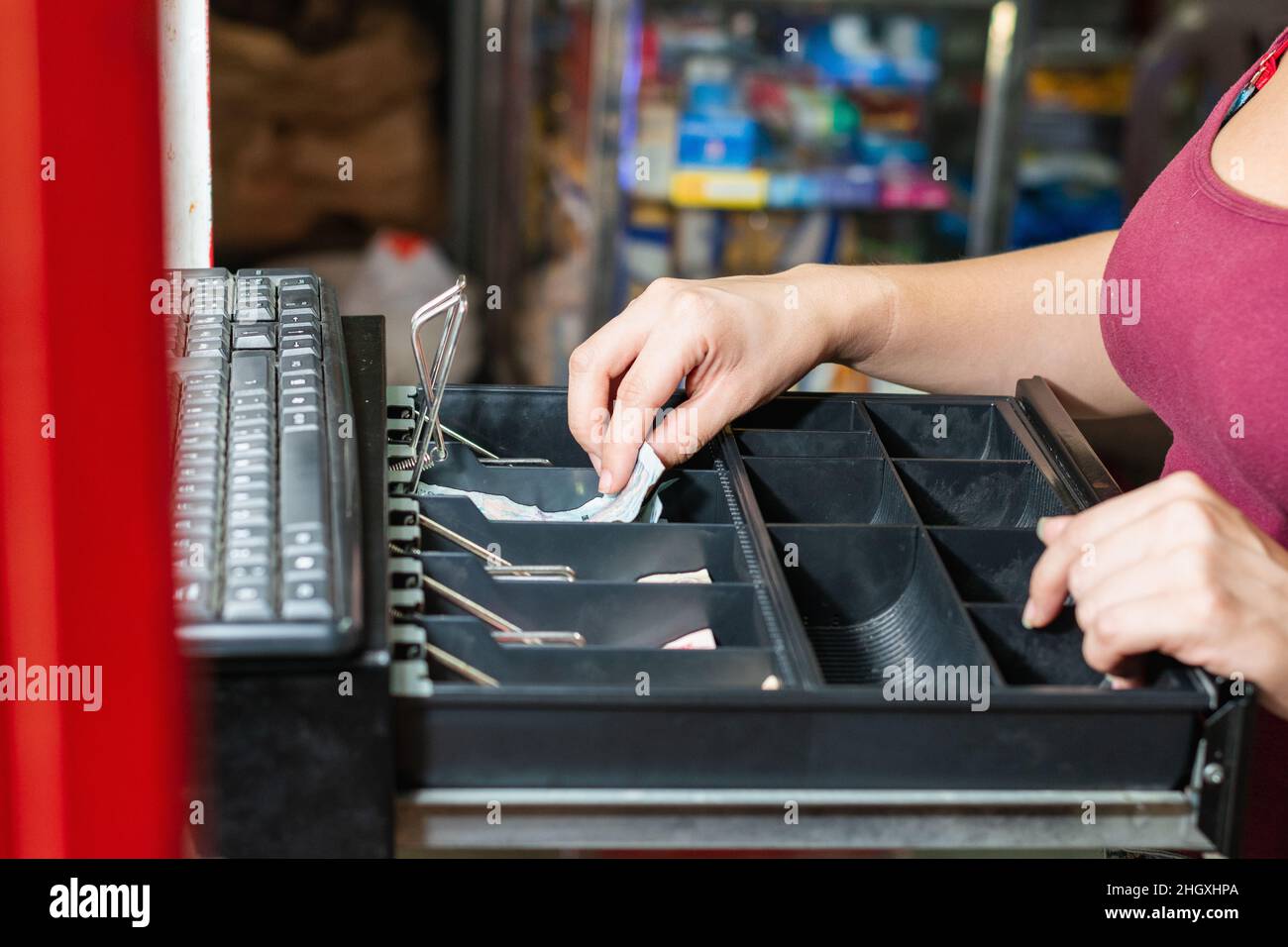 hand of an enterprising latina woman in her business opening the cash ...