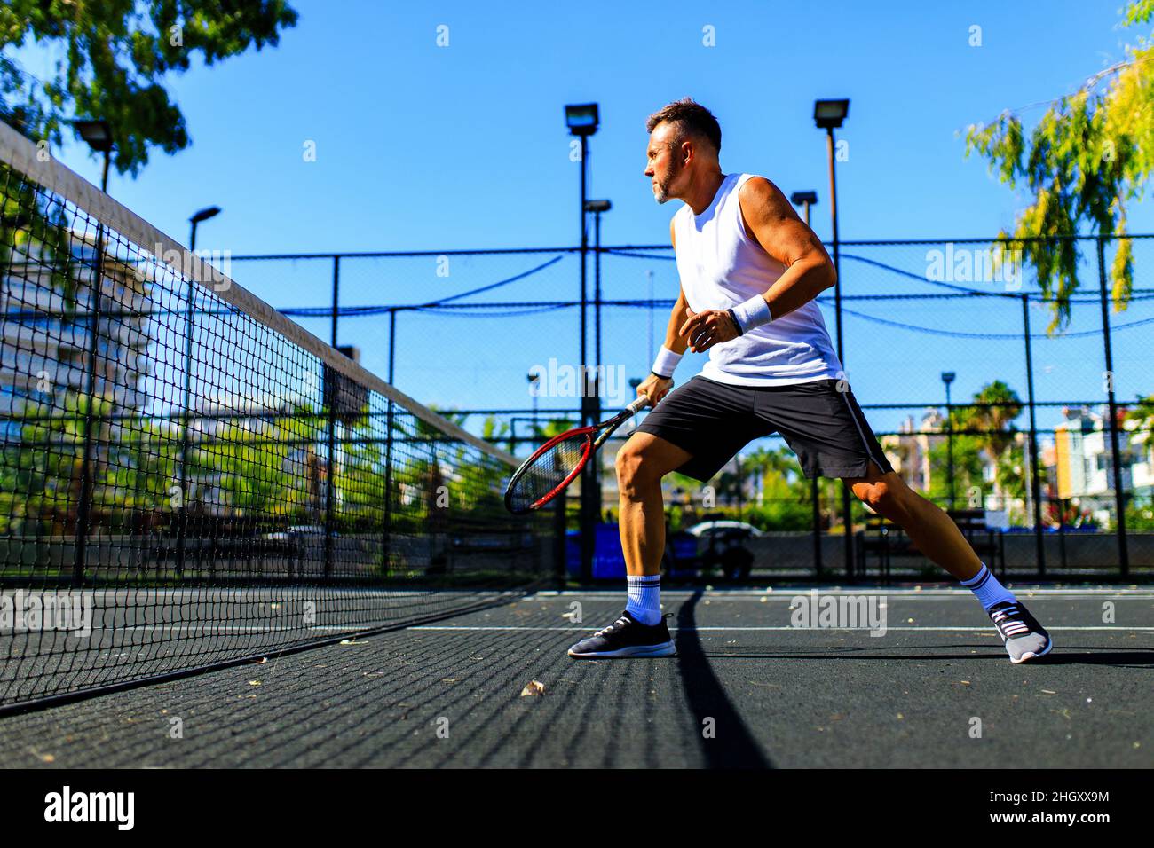 mature handsome man playing tennis on tennis court at sunny day Stock ...