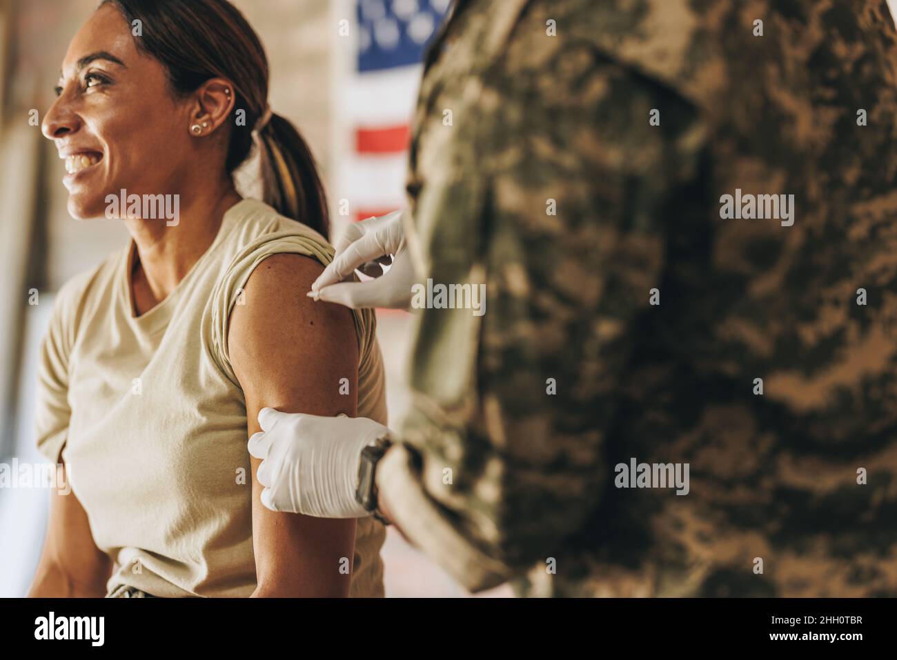 Happy servicewoman smiling cheerfully before an injection in the ...