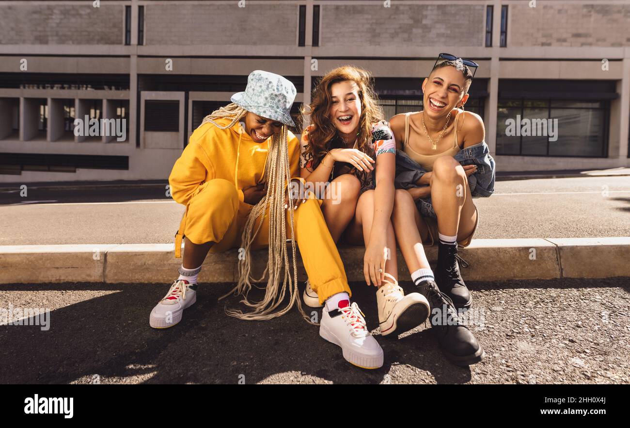 Group of female friends laughing cheerfully in the city. Generation z ...
