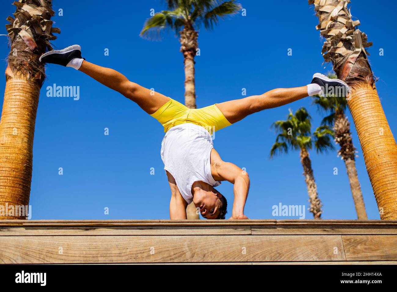 young man man performing dance movement standing on hand outdoors in ...