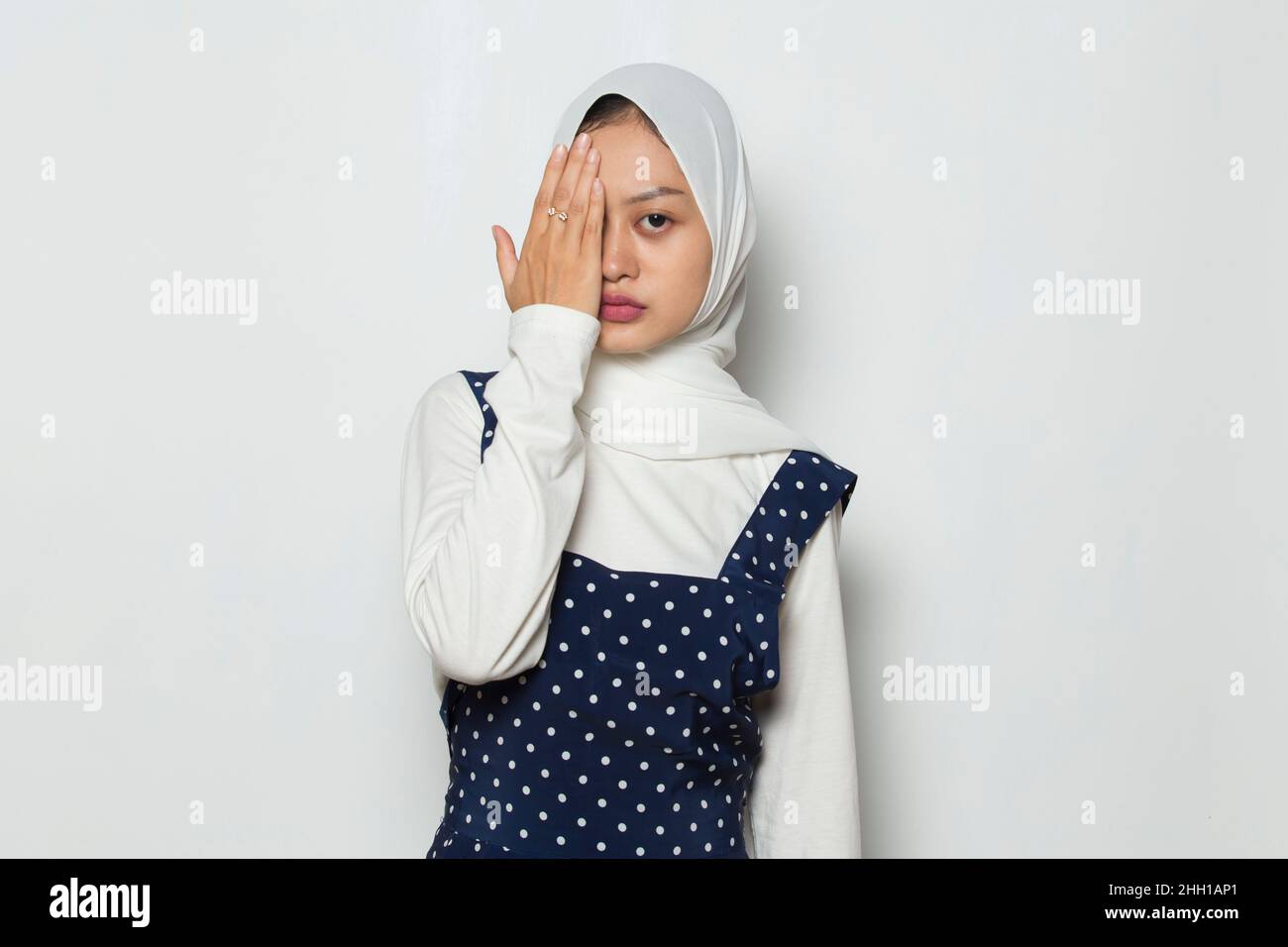 asian muslim woman covering one eye with hand Stock Photo - Alamy