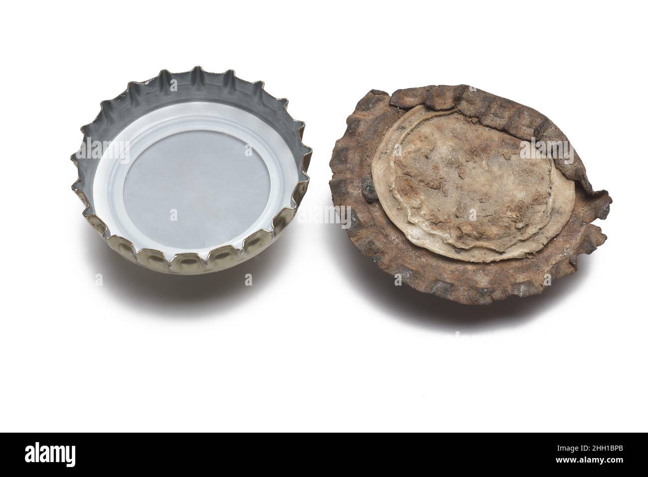 Close up of two crown caps seen from below with one new and one rusty ...