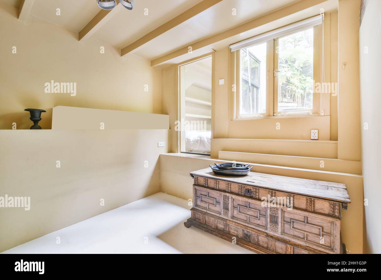 Lovely room with a wooden chest and a window on the wall Stock Photo ...