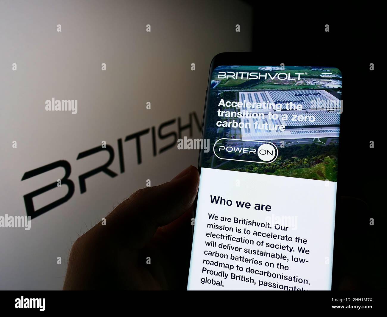 Person holding cellphone with webpage of battery company Power by ...